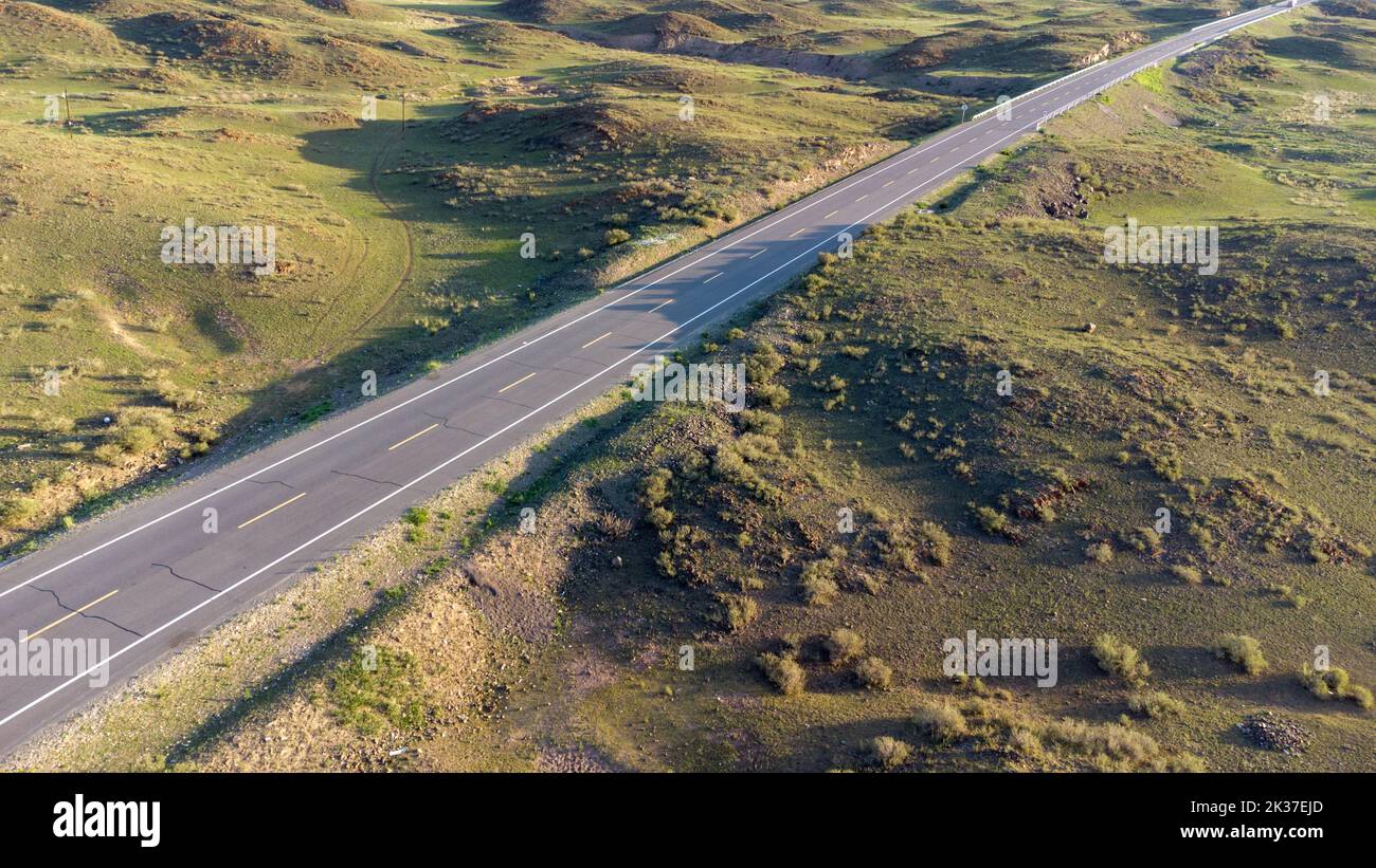 A long straight asphalt road in the middle of the valley Stock Photo ...
