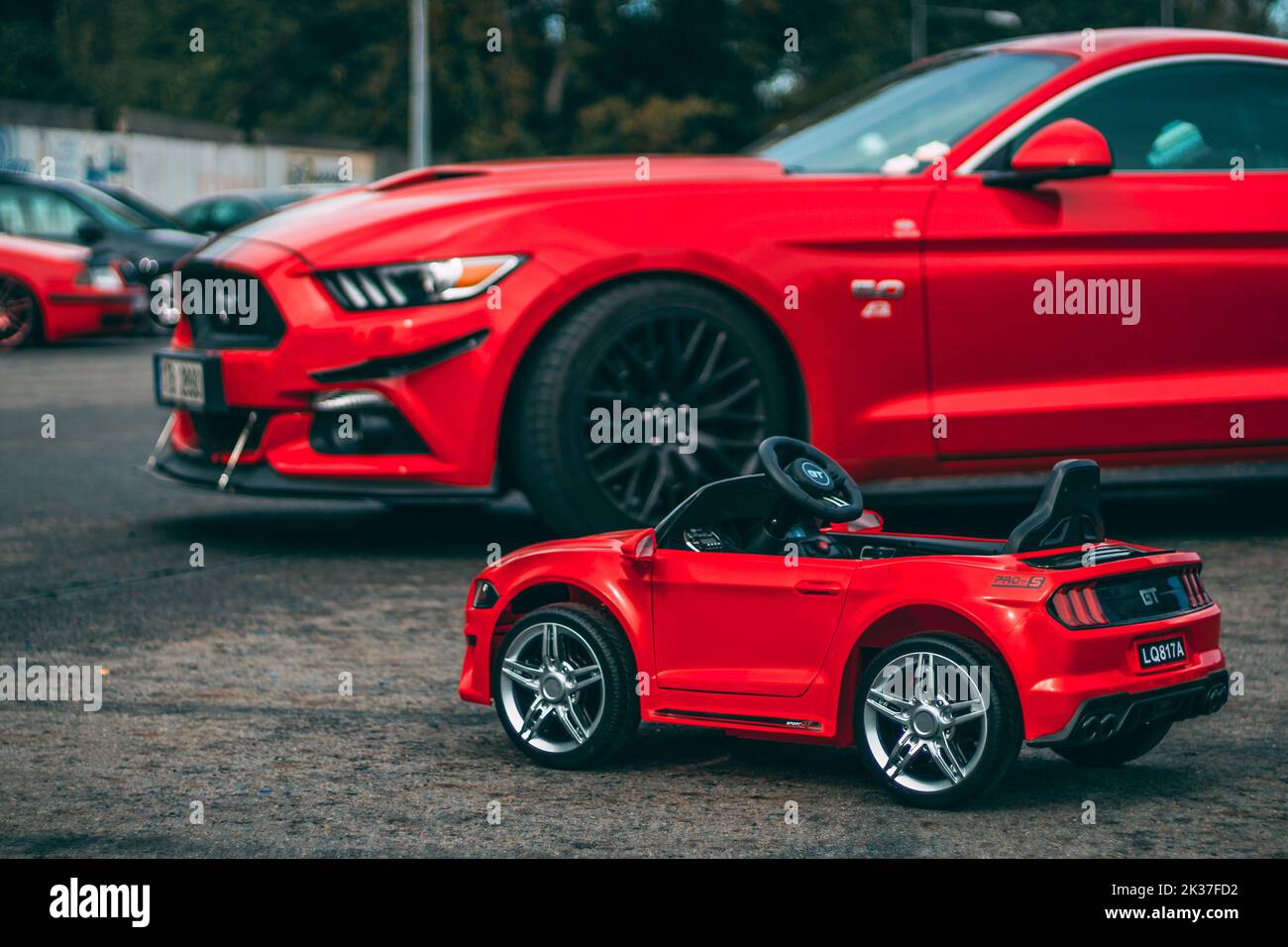 A closeup shot of kids' pedal car of a Ford Mustang GT parked next to ...