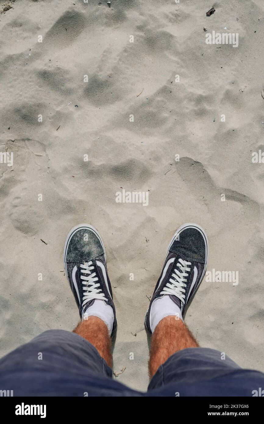 A vertical top view of shoes standing on the sand with copy space Stock ...