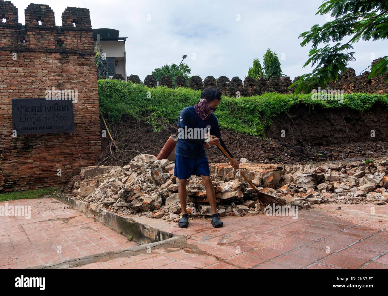 A worker from Chiang Mai Municipality sweeps damaged bricks of the ...