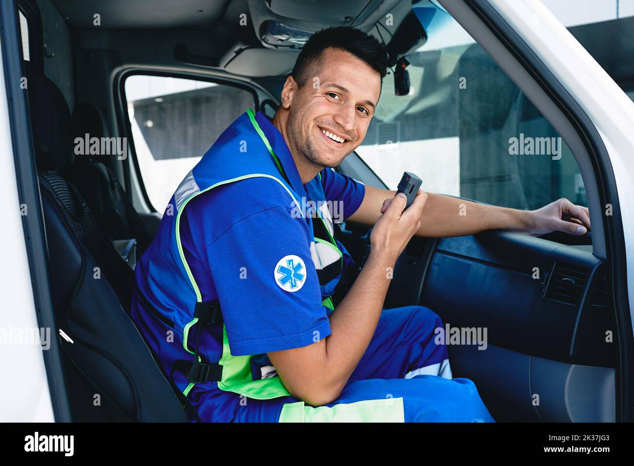Emergency medical services worker. Smiling male paramedic talking on ...