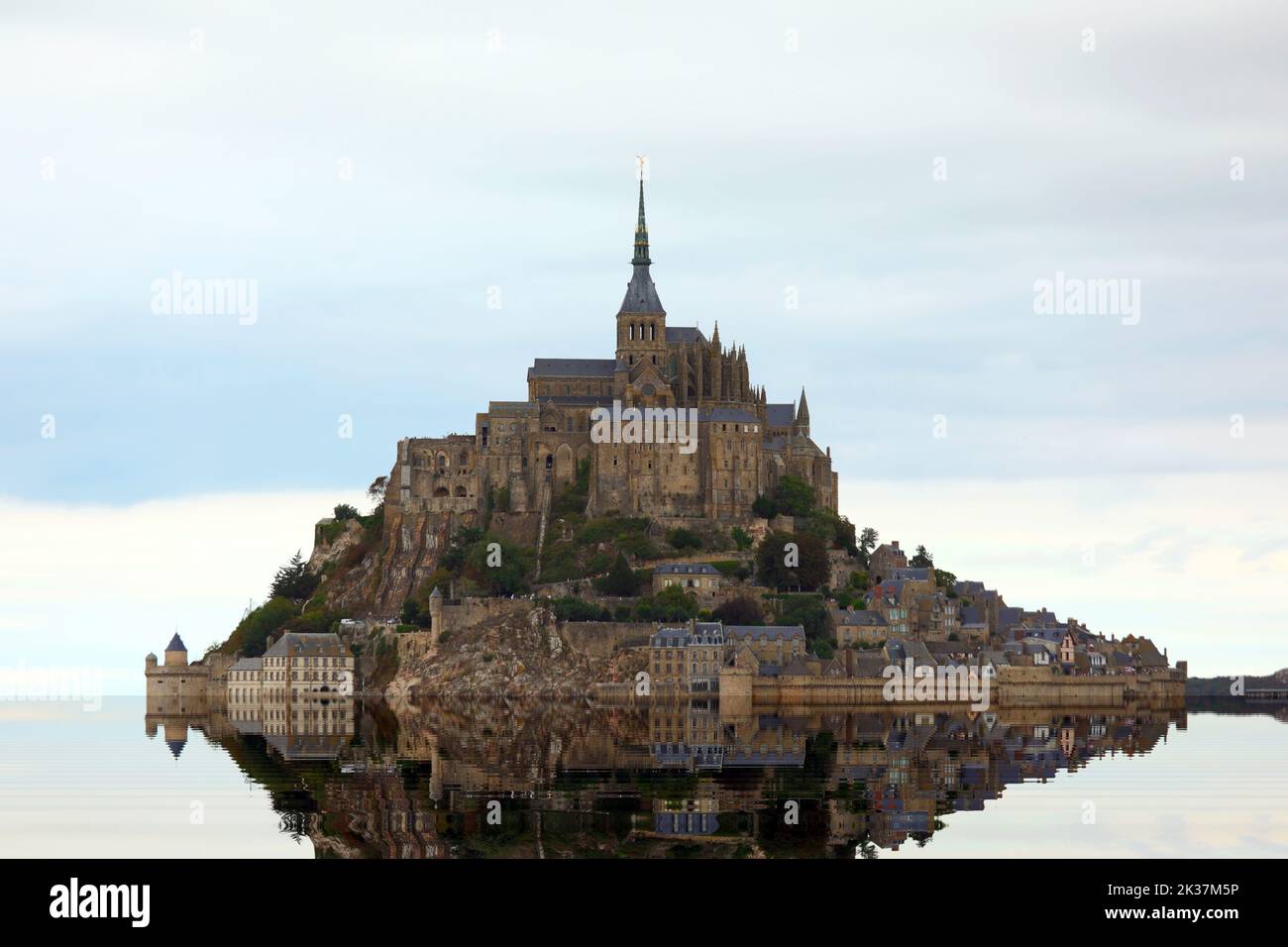reflection of the sea and the famous Abbey of Mont Saint Michel in the ...