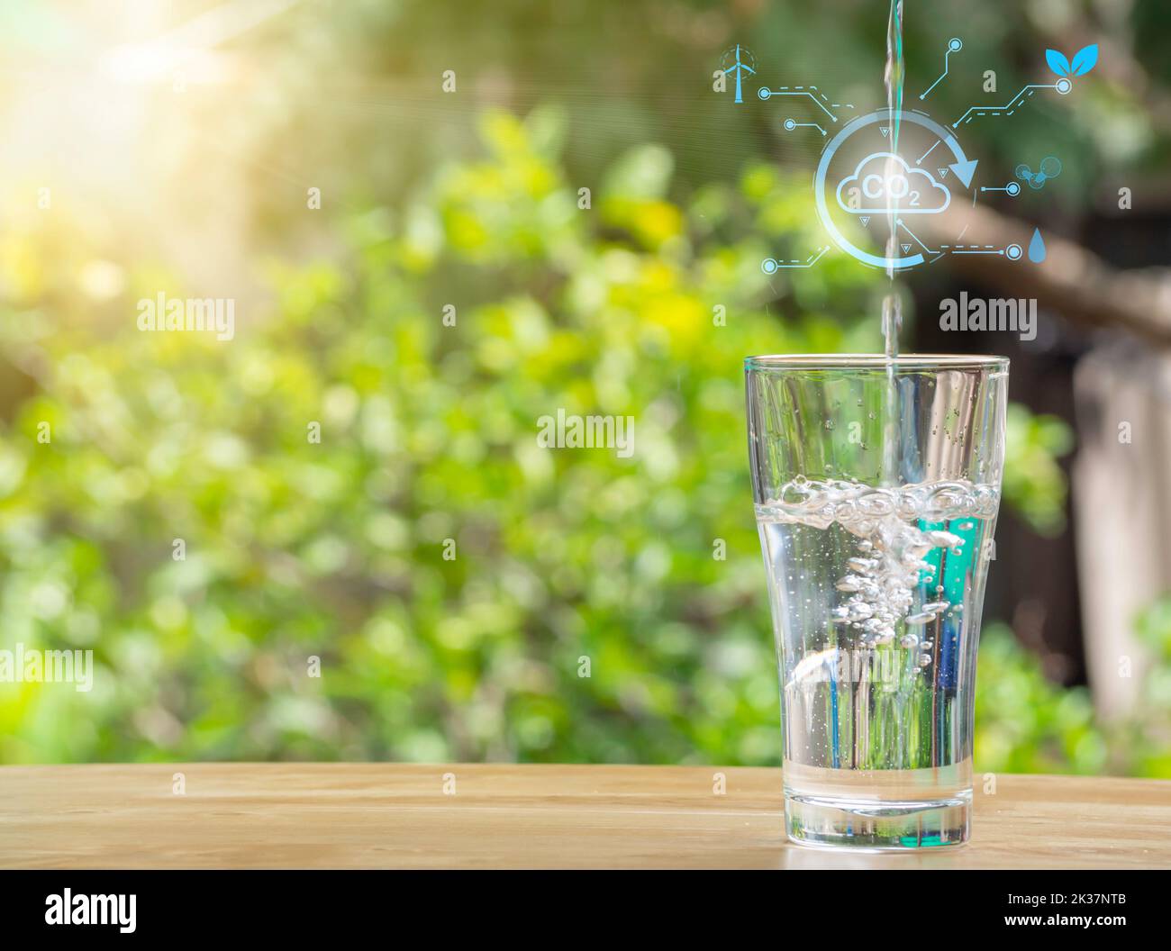 The pure water from jug into glass with CO2 icon on wooden table on ...