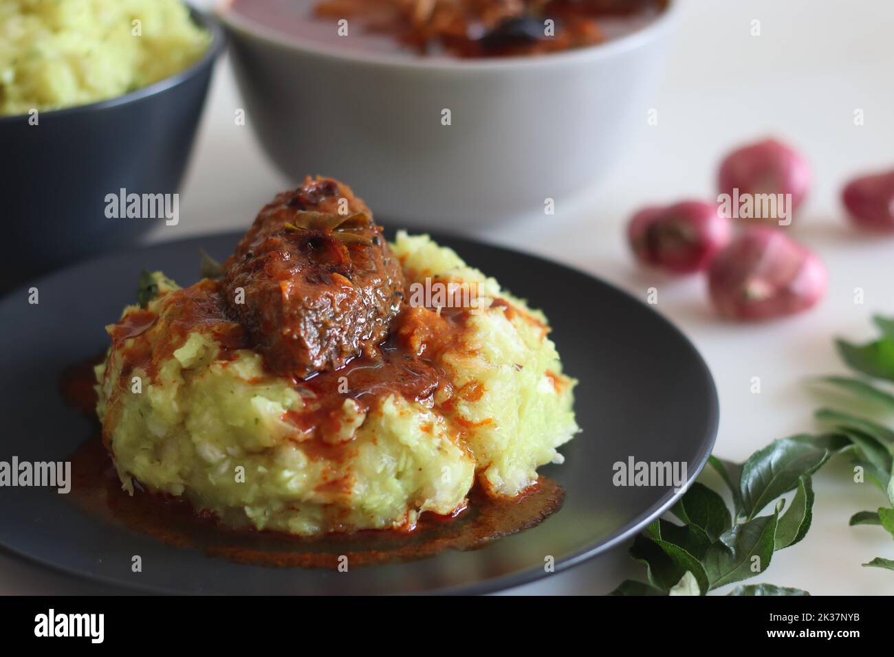 Mashed tapioca served with pomfret fish curry. Boiled and strained ...