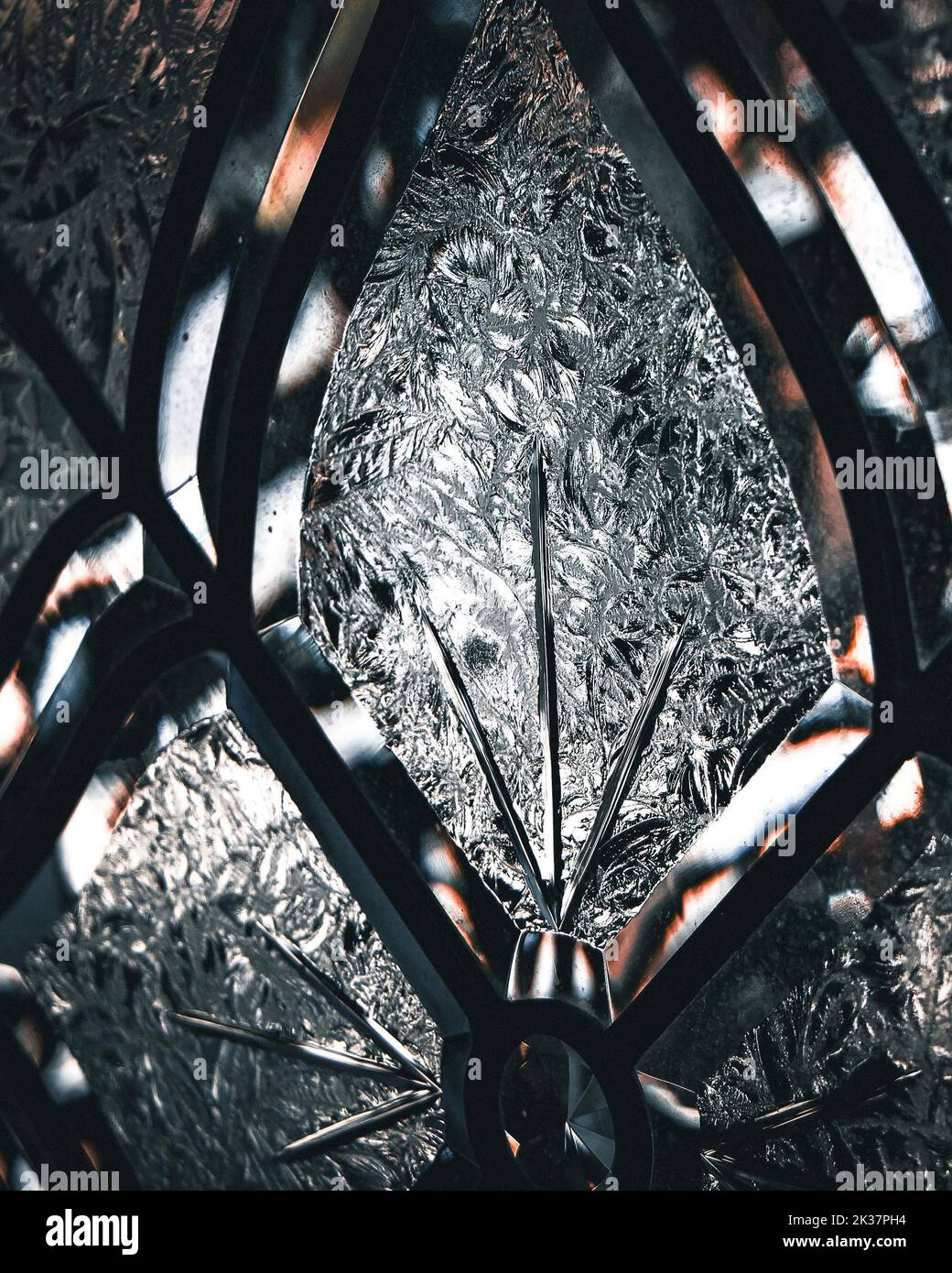 A closeup of a drop-like shaped lead glass with light passing through ...