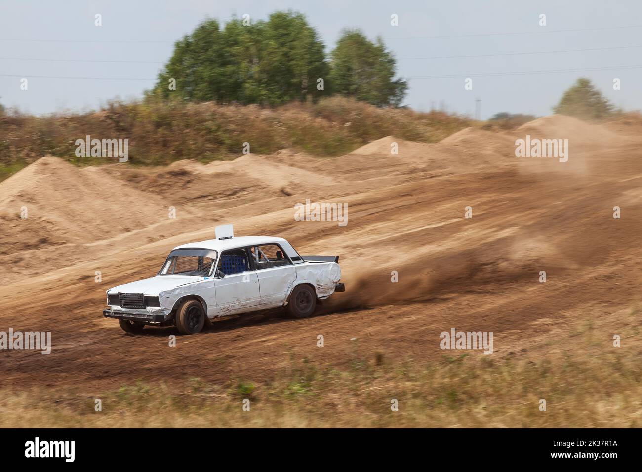 Rally off-road car make a turn with the clouds and splashes of sand ...
