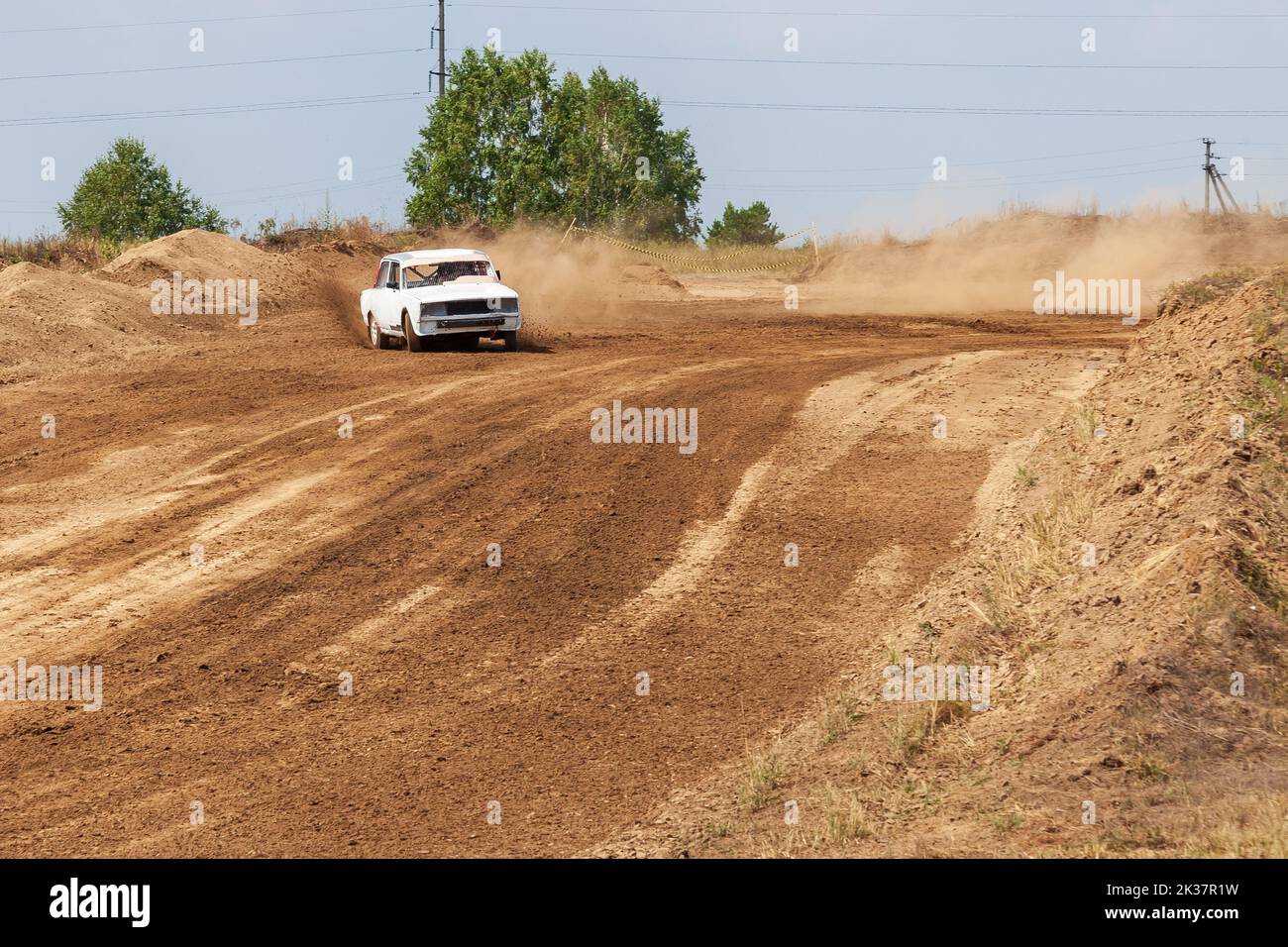 Rally off-road car make a turn with the clouds and splashes of sand ...