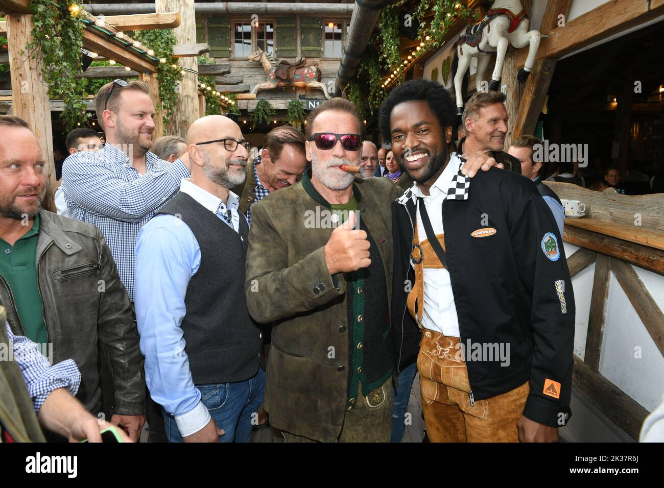 Munich, Germany. 25th Sep, 2022. Actor Arnold Schwarzenegger (M) shows ...
