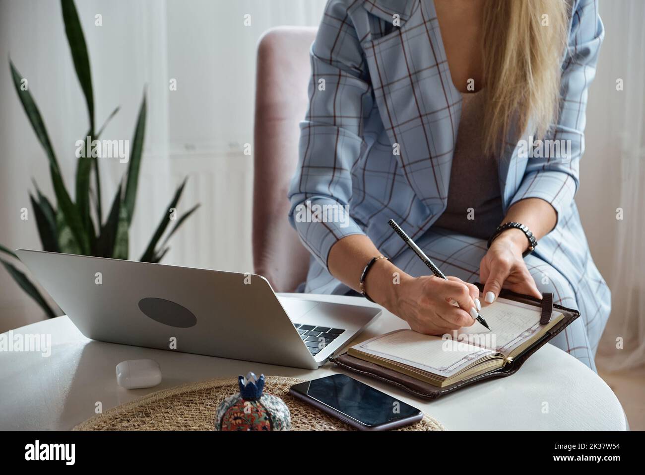 Unrecognizable Young woman making notes in notebook sitting at ...