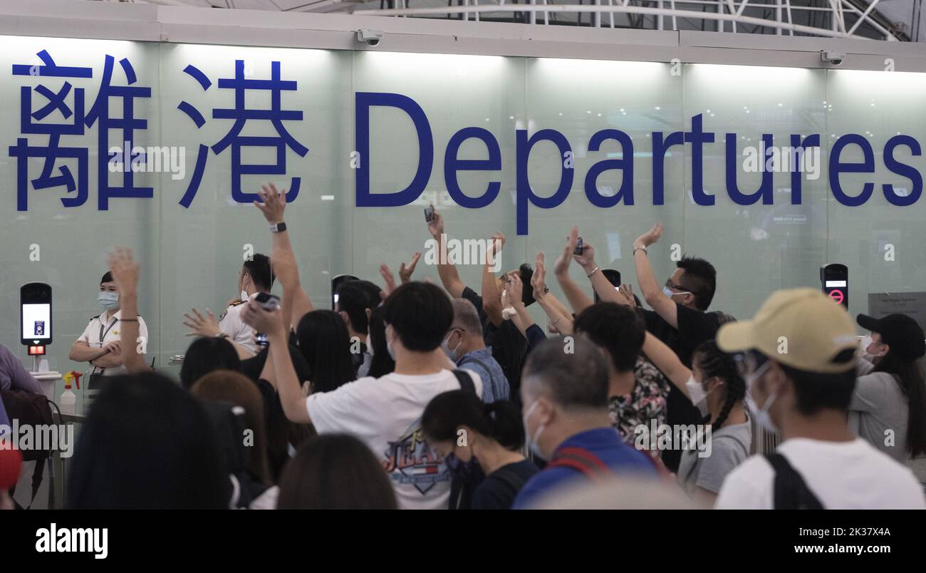 Friends and family wave goodbye to travelers at departures area on Hong ...