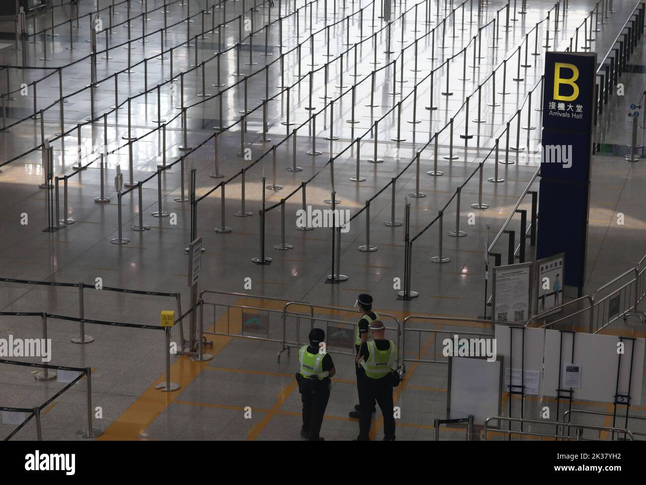 Security guards chat at an empty arrivals hall in the Hong Kong ...