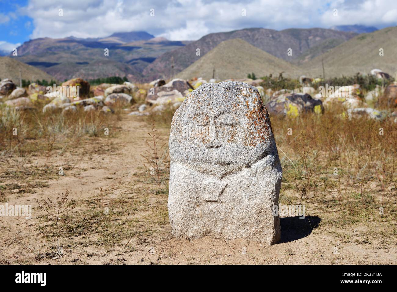 Ancient turkic stone statue depictures a man against mountains. VII-X ...