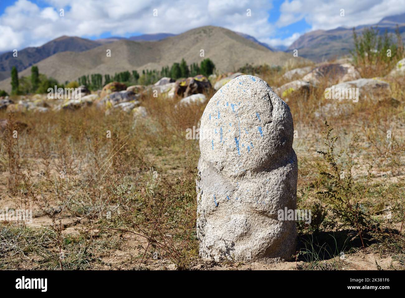 Ancient turkic stone statue depictures a man against mountains. VII-X ...