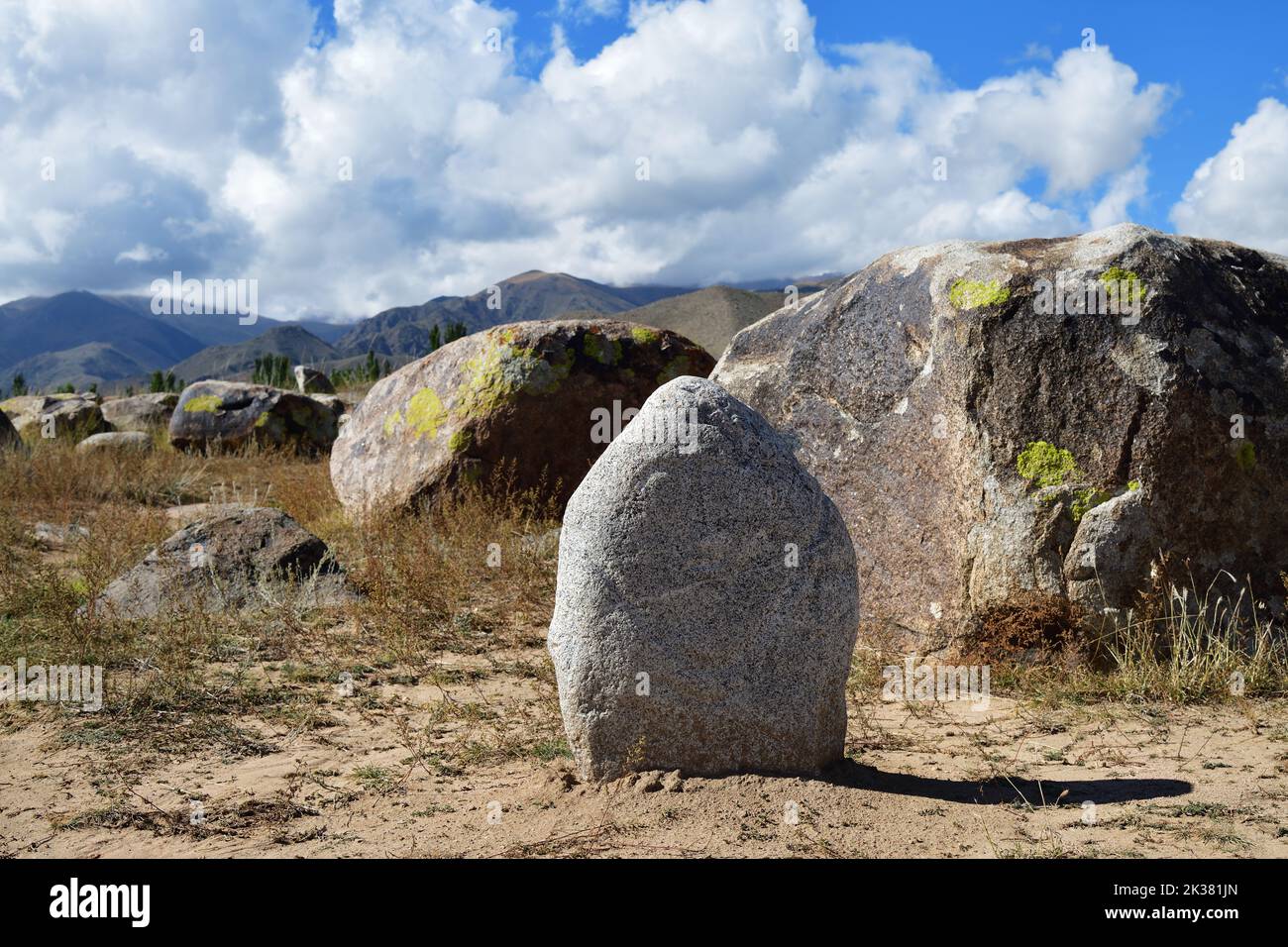 Ancient turkic stone statue depictures a man against mountains. VII-X ...