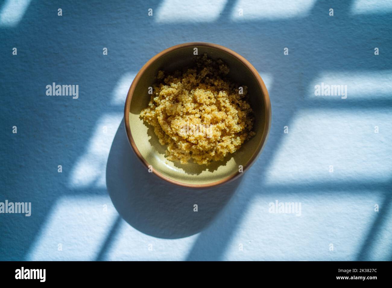 A top view of a rustic bowl with quinoa oatmeal on the white table with ...