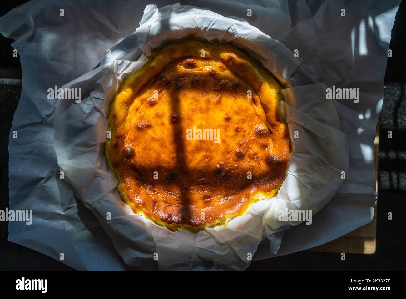 A rustic top view of a Basque cheesecake with beautiful sunlight and ...