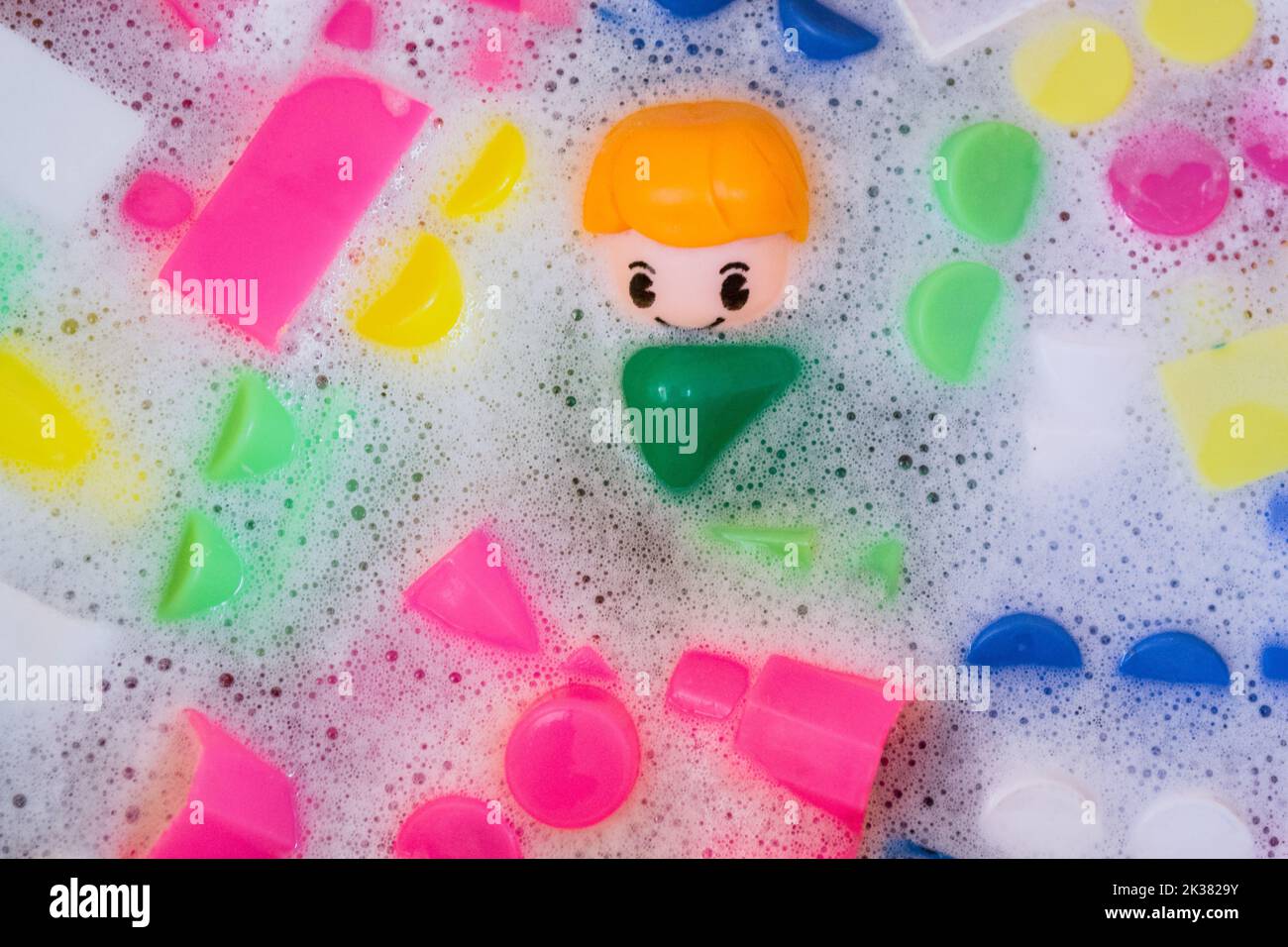Washing of children toys, plastic building blocks with figurines. A ...