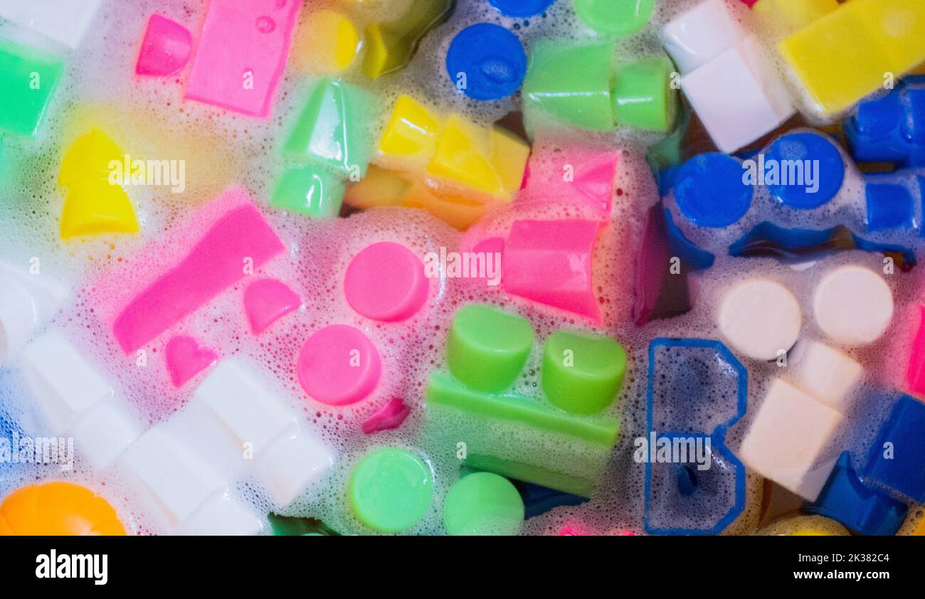 Washing of childrens toys, plastic building blocks. Colorful cubes ...