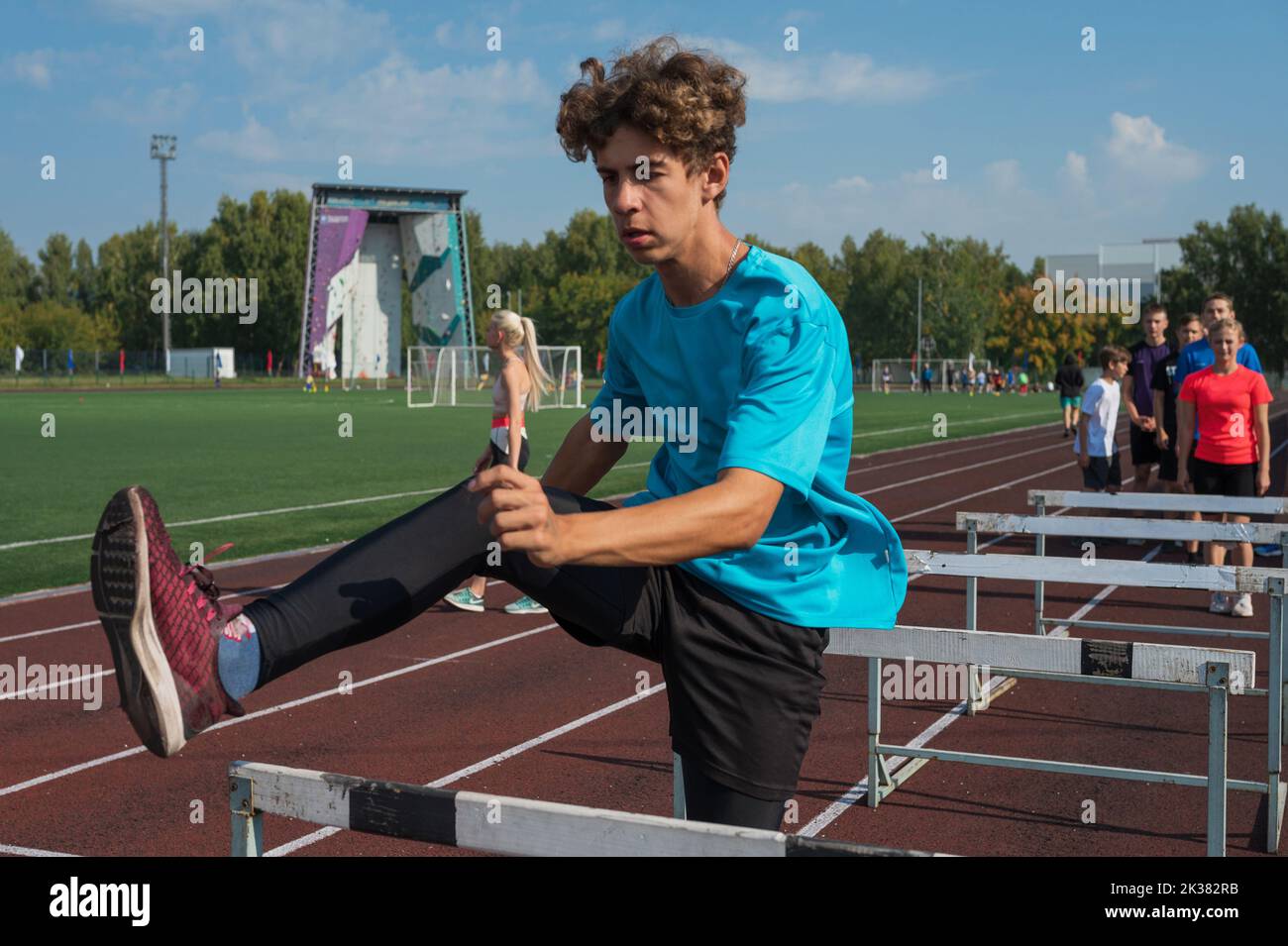 Young man athlete runnner running hurdles at the stadium outdoors Stock ...