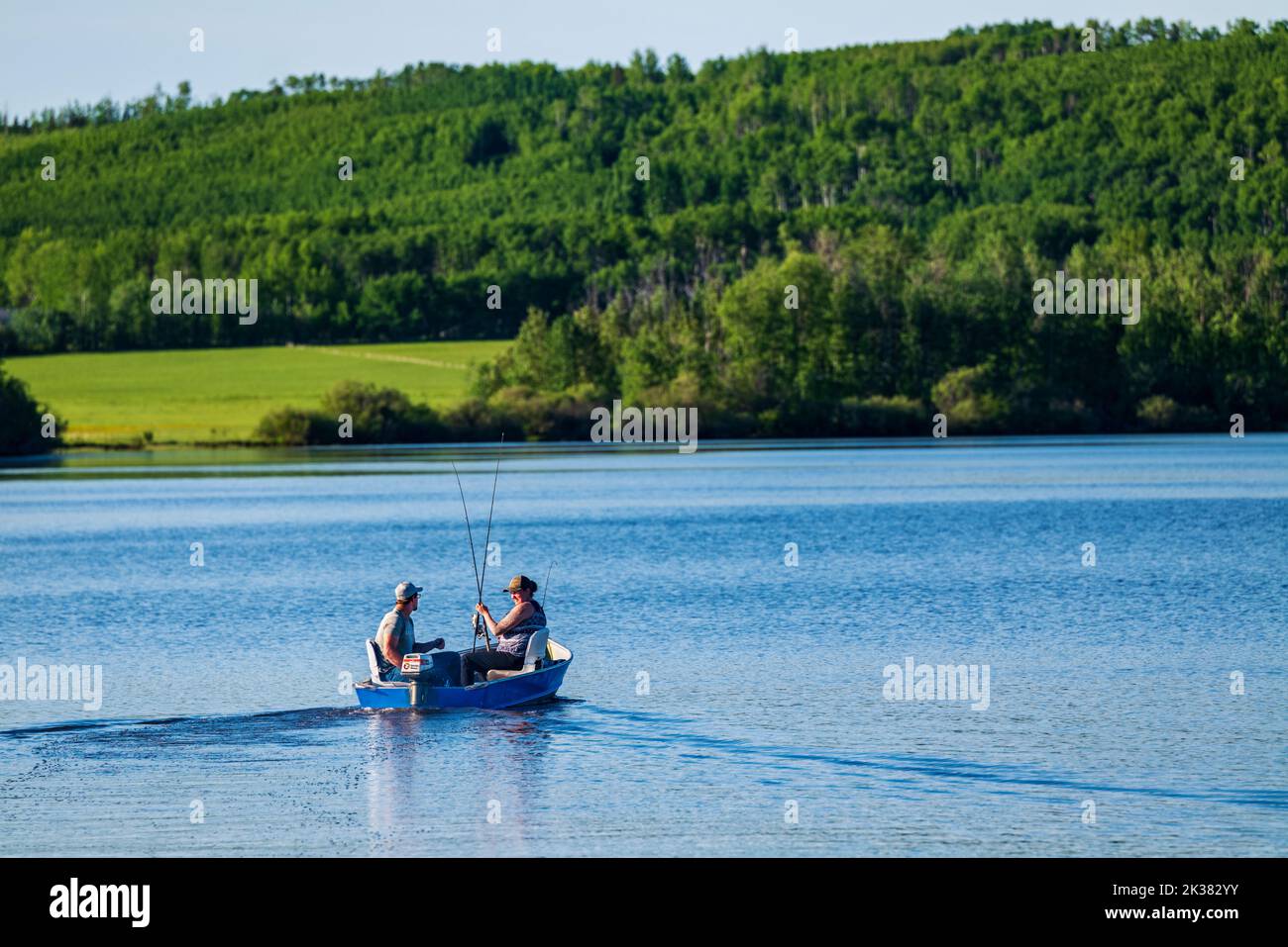 Couple fishing from small motorboat; Swan Lake Provincial Park; British ...