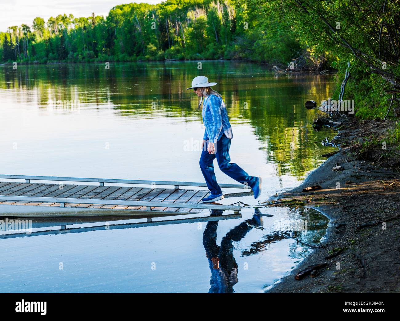 Lone senior woman on dock; Swan Lake; Swan Lake Provincial Park ...