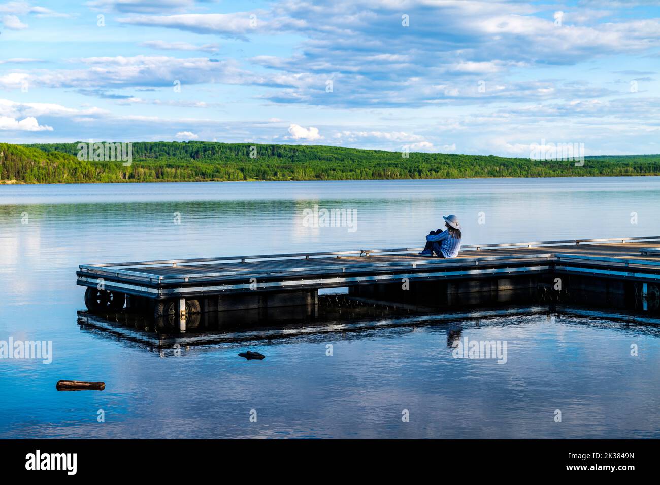 Lone senior woman on dock; Swan Lake; Swan Lake Provincial Park ...