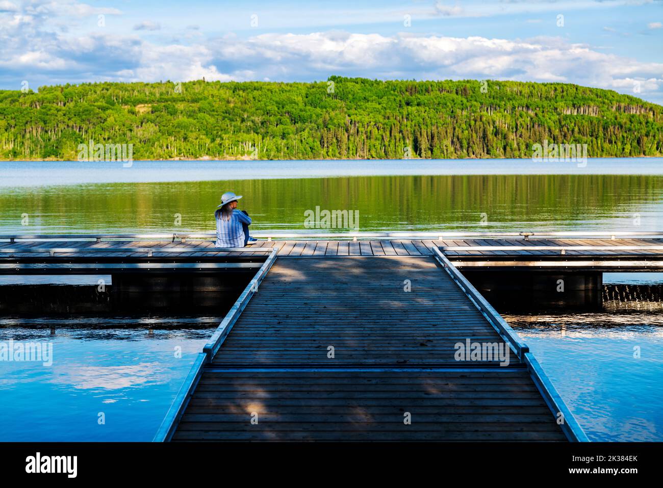 Lone senior woman on dock; Swan Lake; Swan Lake Provincial Park ...