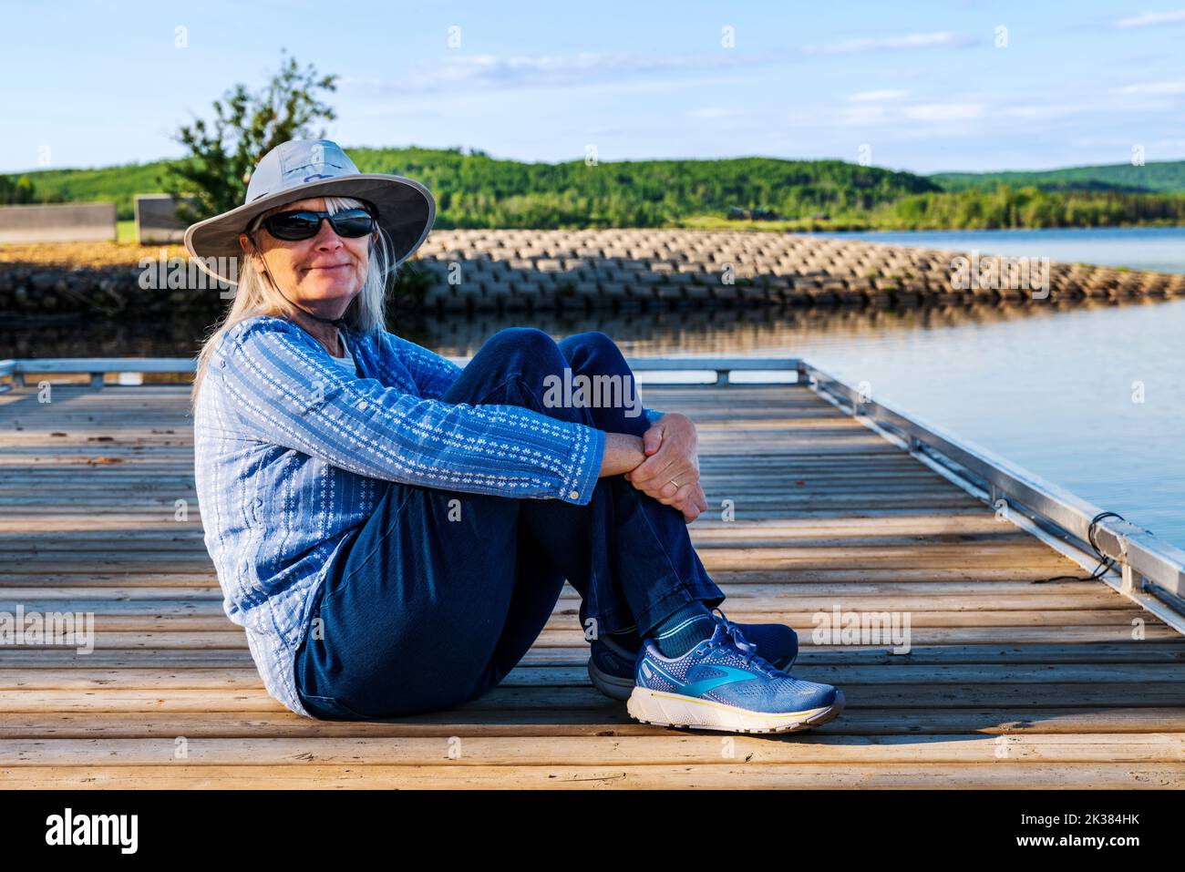 Lone senior woman on dock; Swan Lake; Swan Lake Provincial Park ...