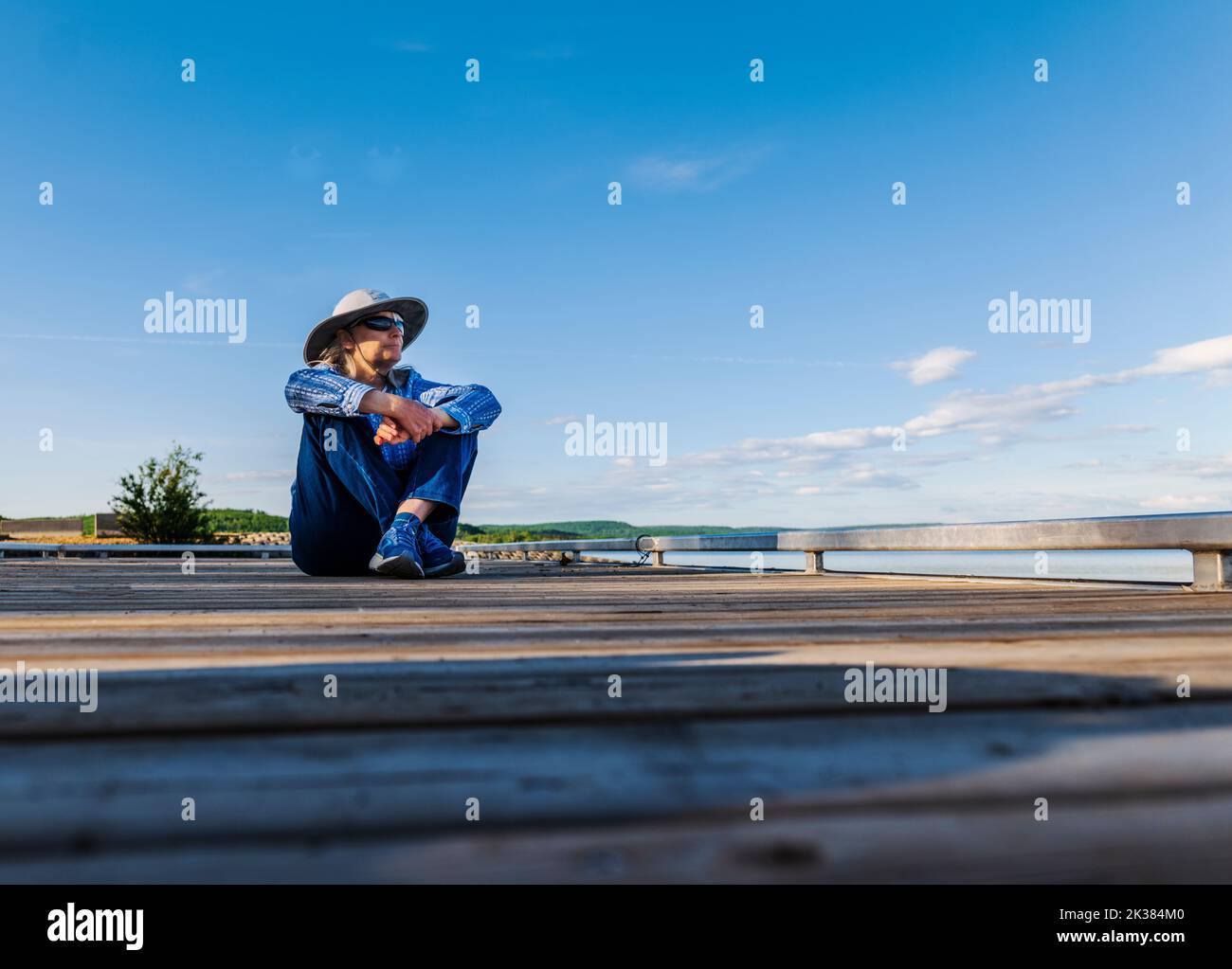 Lone senior woman on dock; Swan Lake; Swan Lake Provincial Park ...