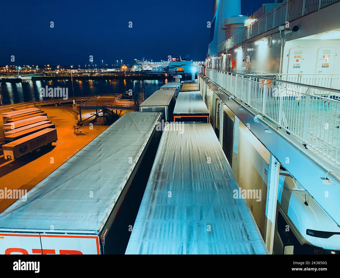 A row of parked lorries and truck trailers on a ferry boat in the port ...
