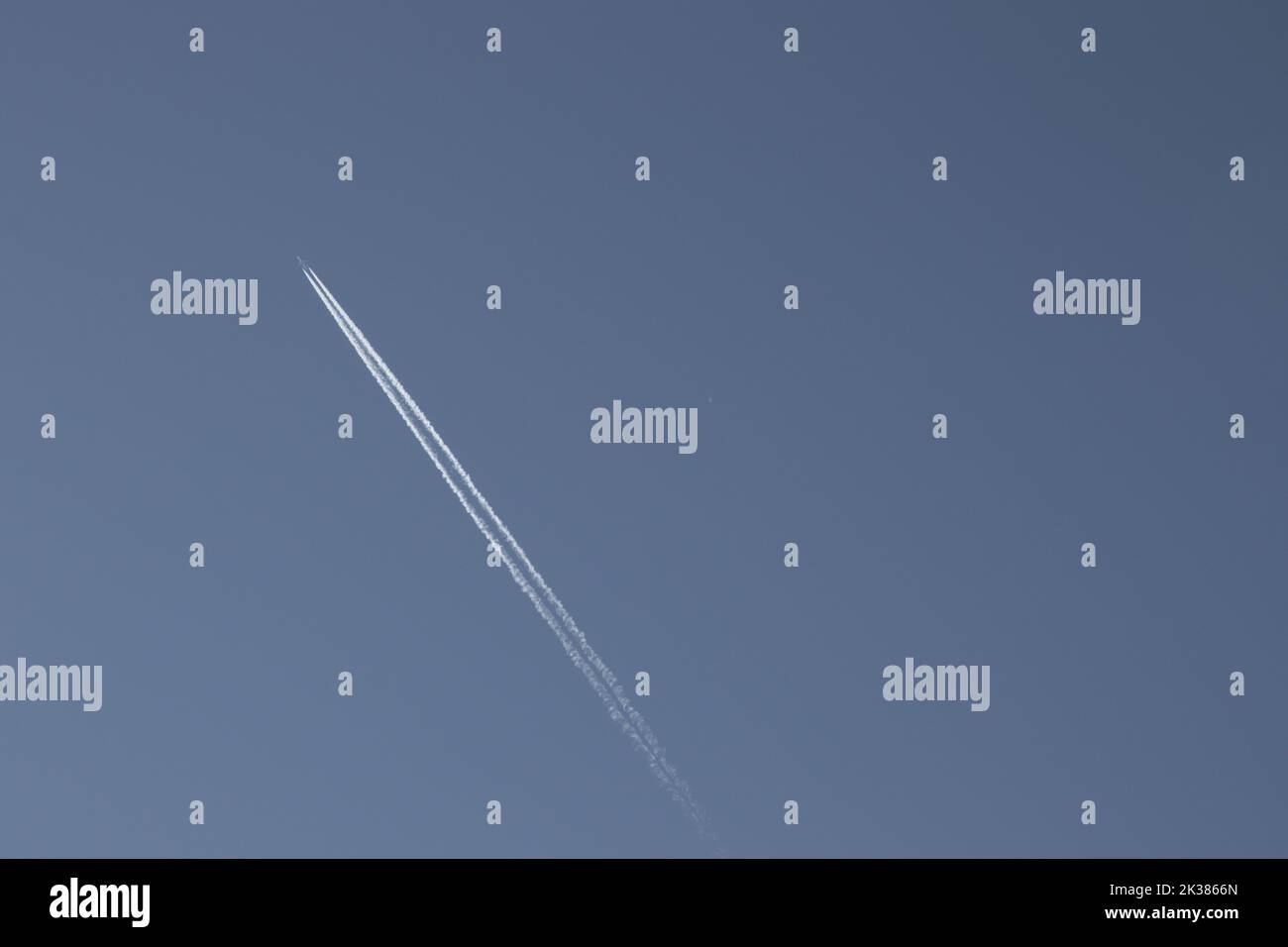 Bacoli, Naples, in the blue sky an airplane leaves a long white trail ...