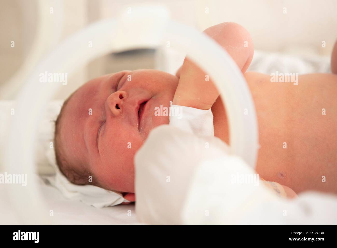 A newborn baby lies in boxes in the hospital. A child in an incubator ...