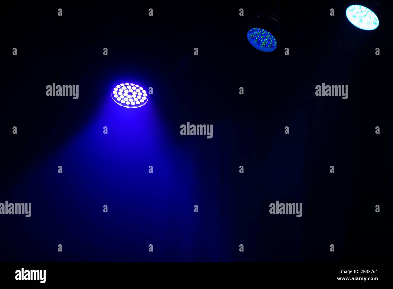 A blue beam of light from a halogen lamp against a dark background ...