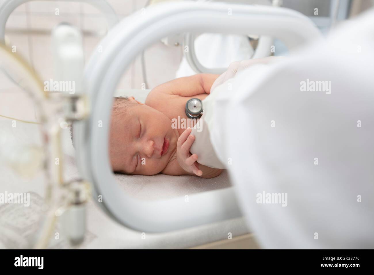A newborn baby lies in boxes in the hospital. A child in an incubator ...