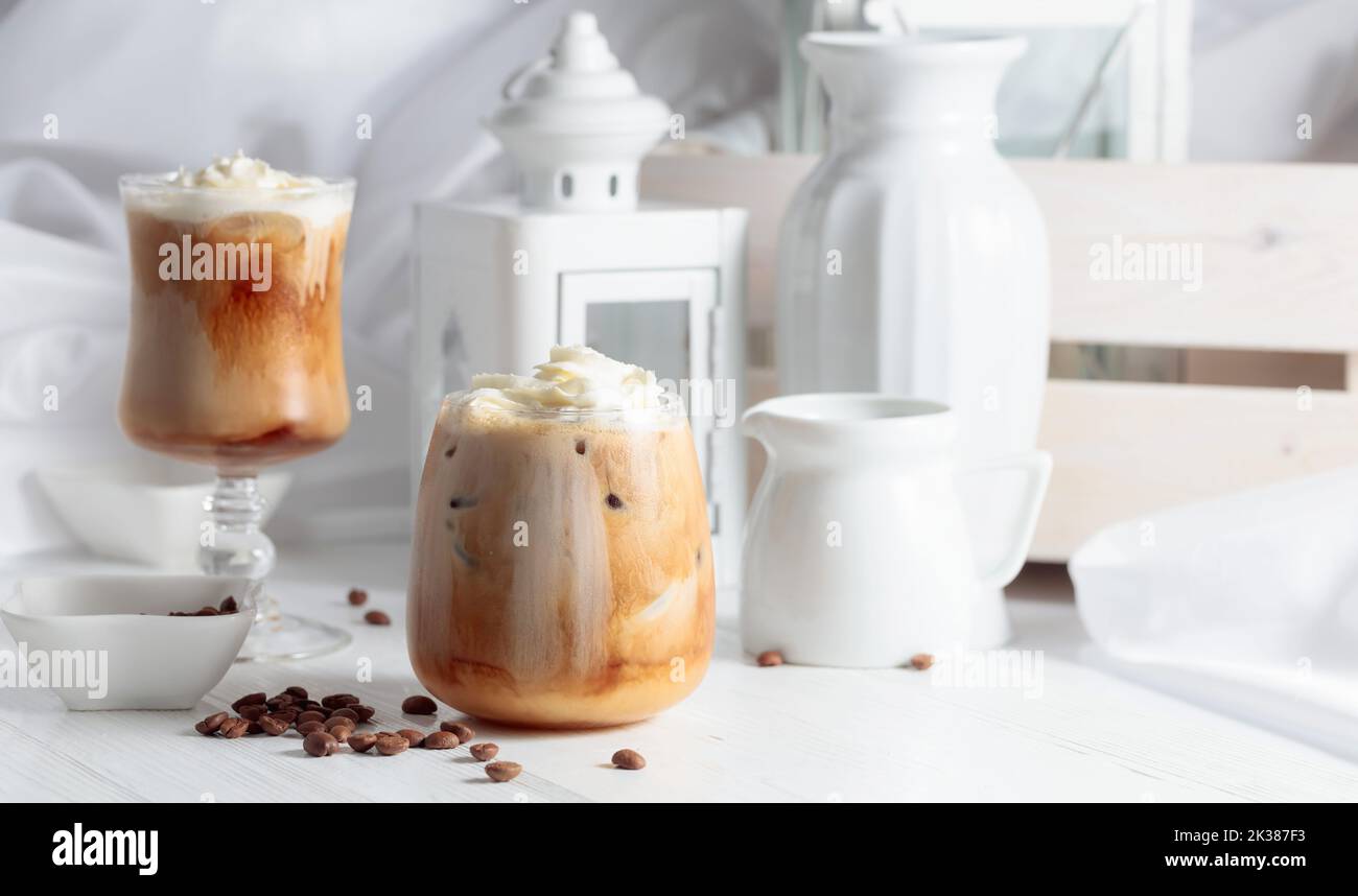 Iced coffee with cream and natural ice on a white wooden table Stock ...