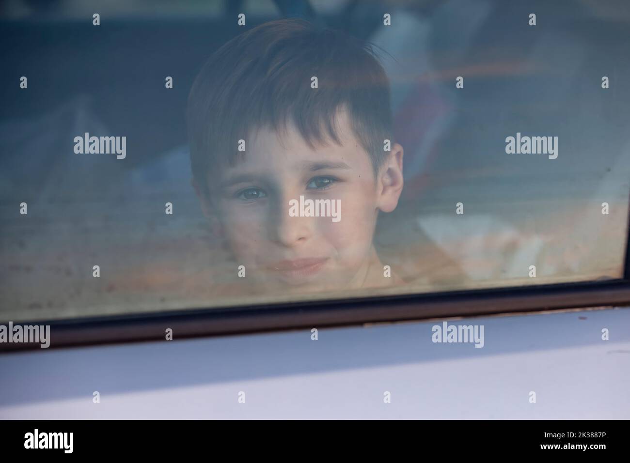 Child in the car. A little boy looks out of the car window Stock Photo ...