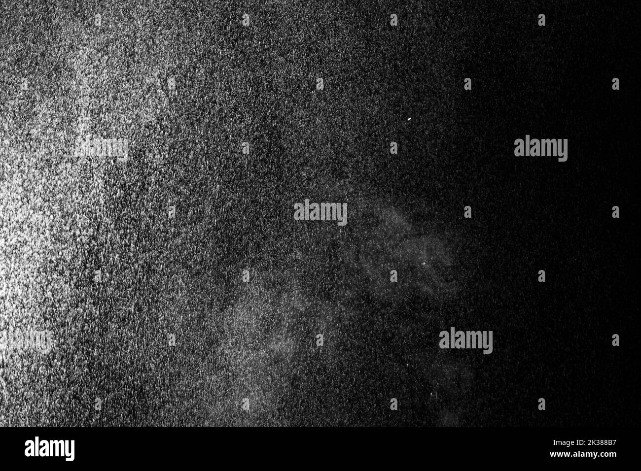 Stream of white curly steam with water drops on a black background ...