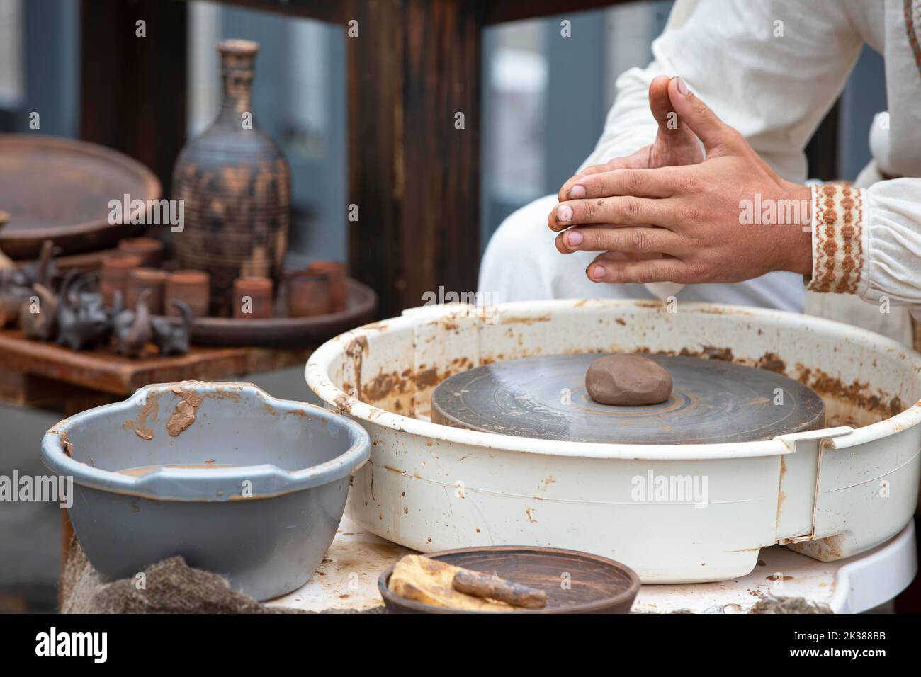 Piece of natural terracotta clay in hands. Wet clay material for ...