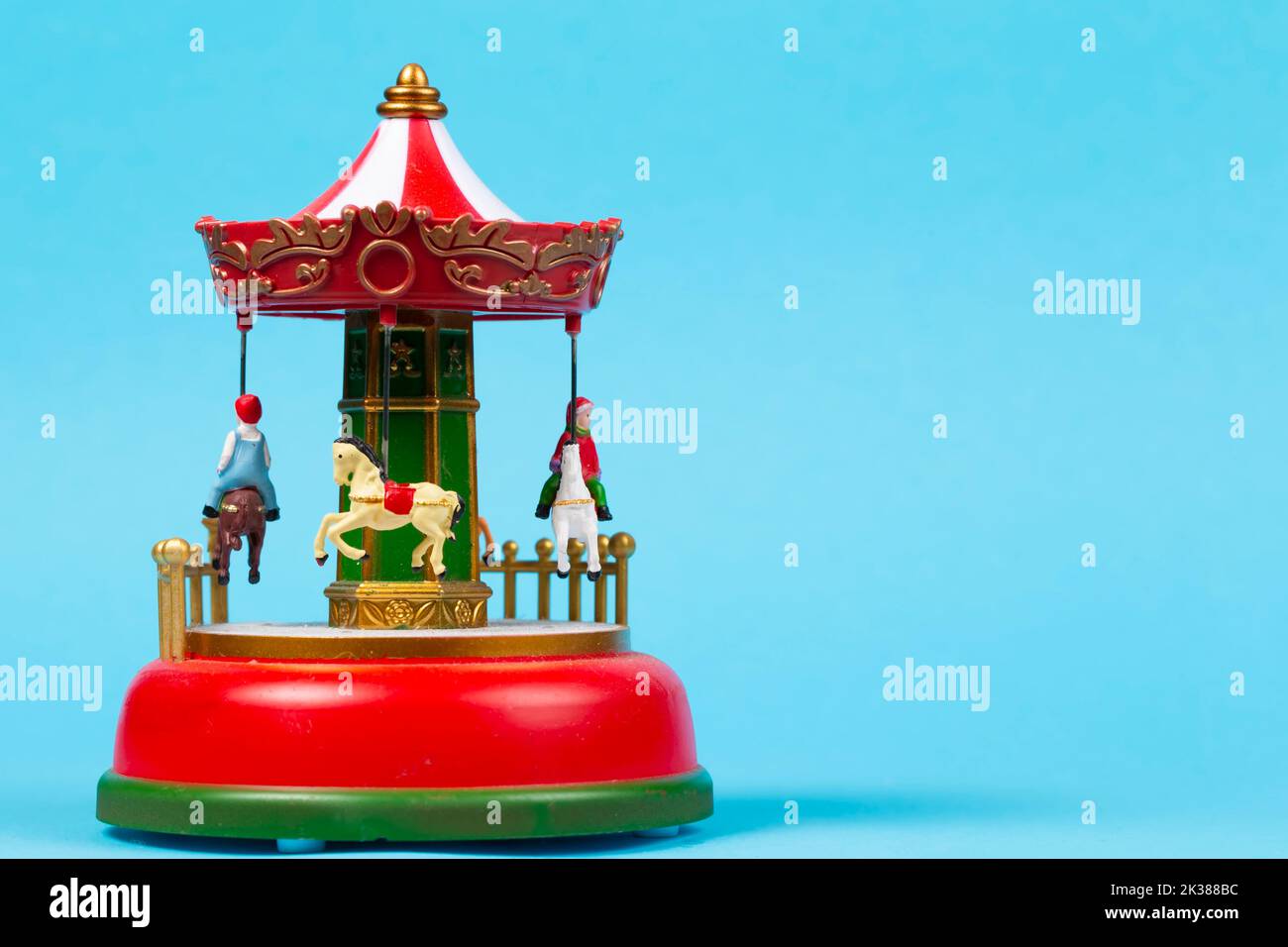 Vintage toy carousel on a blue background. Red carillon with carousel ...