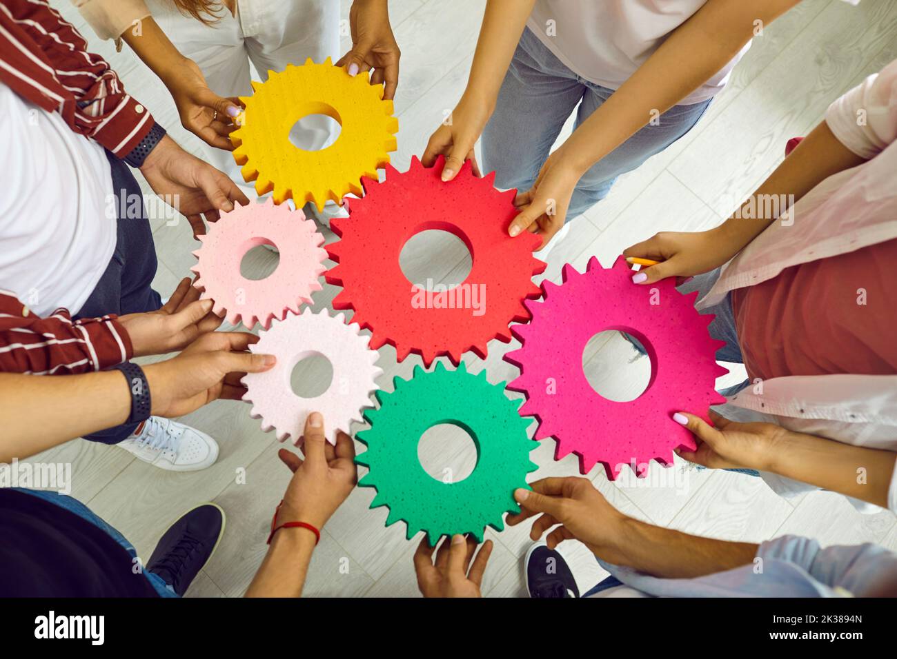 Team of young people connecting gears illustrating concept of teamwork ...