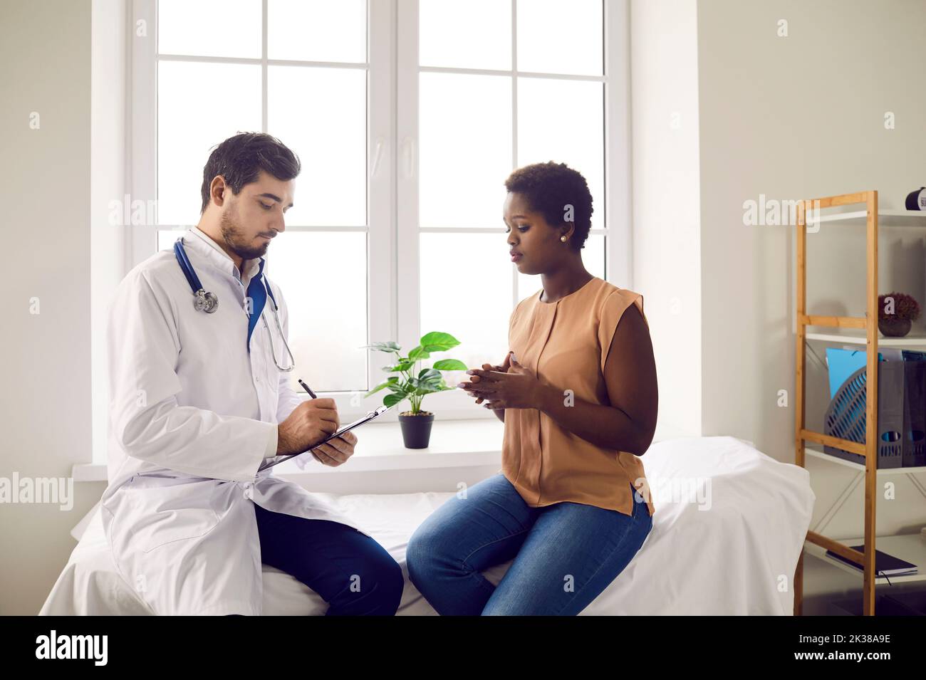 Doctor write prescription to woman patient at consultation Stock Photo ...