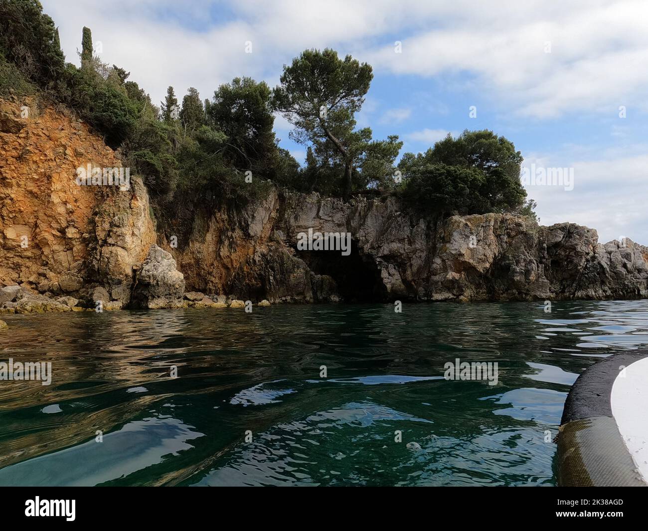 A rocky cave on an island surrounded by water Stock Photo - Alamy