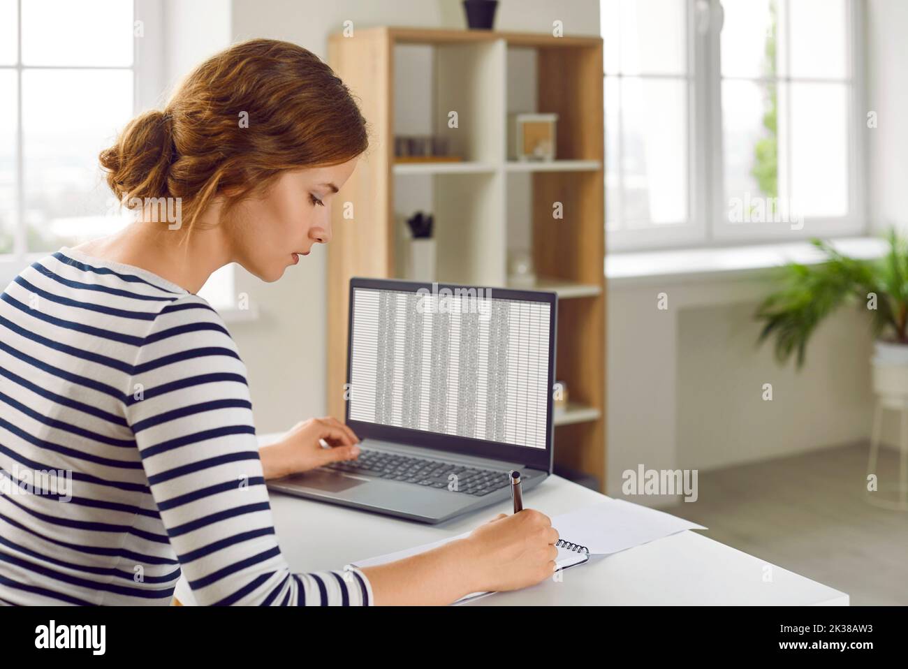 Woman office worker is working with spreadsheet on computers screens ...