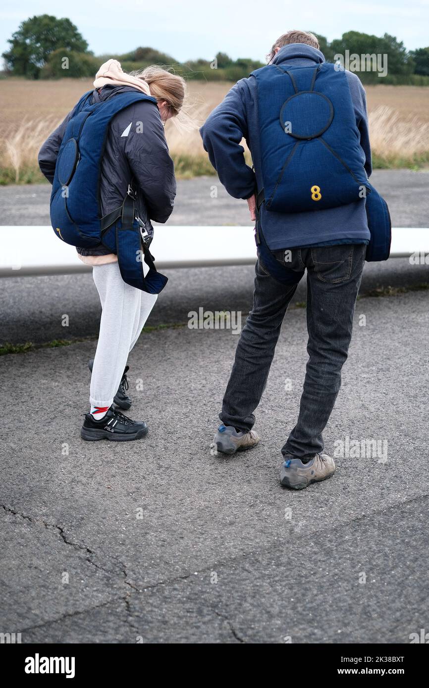 A passenger and pilot secure parachutes before a glider flight at York ...