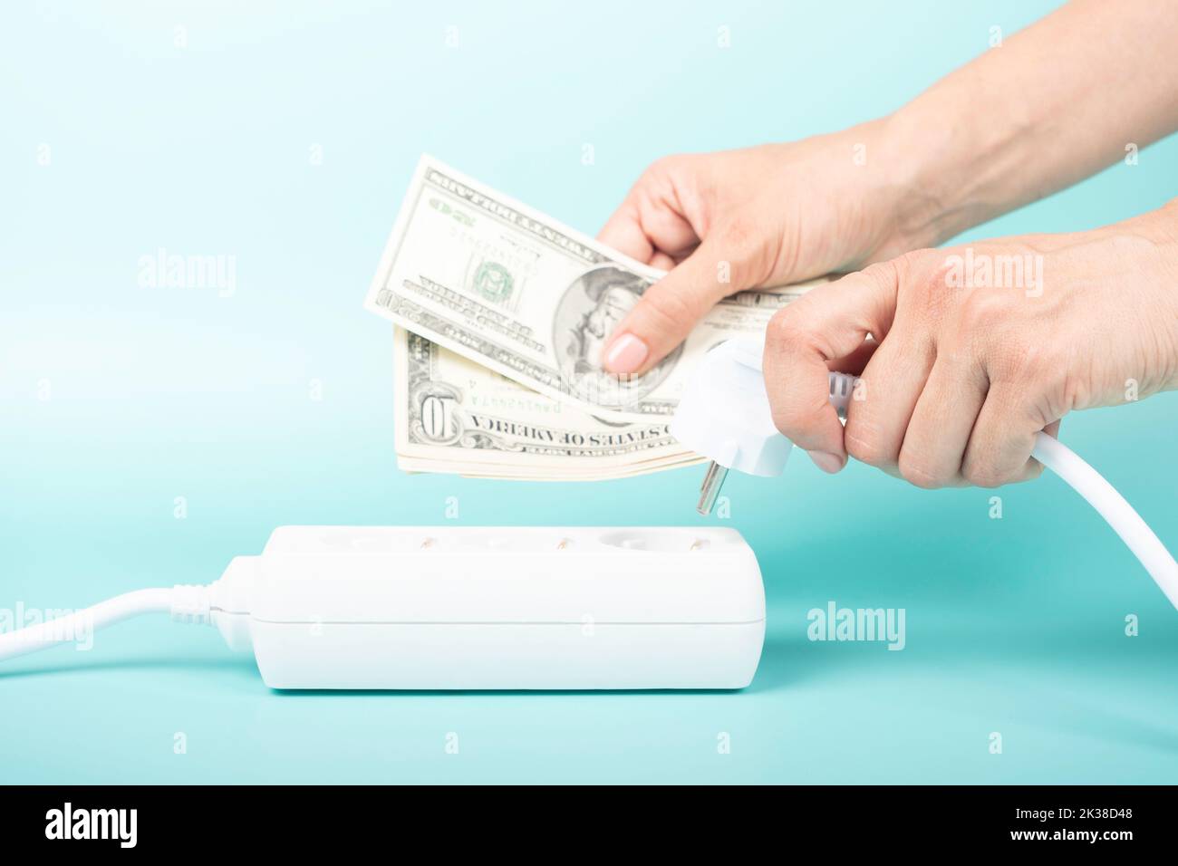 Woman hands holding electric power plug and US dollar banknotes near ...