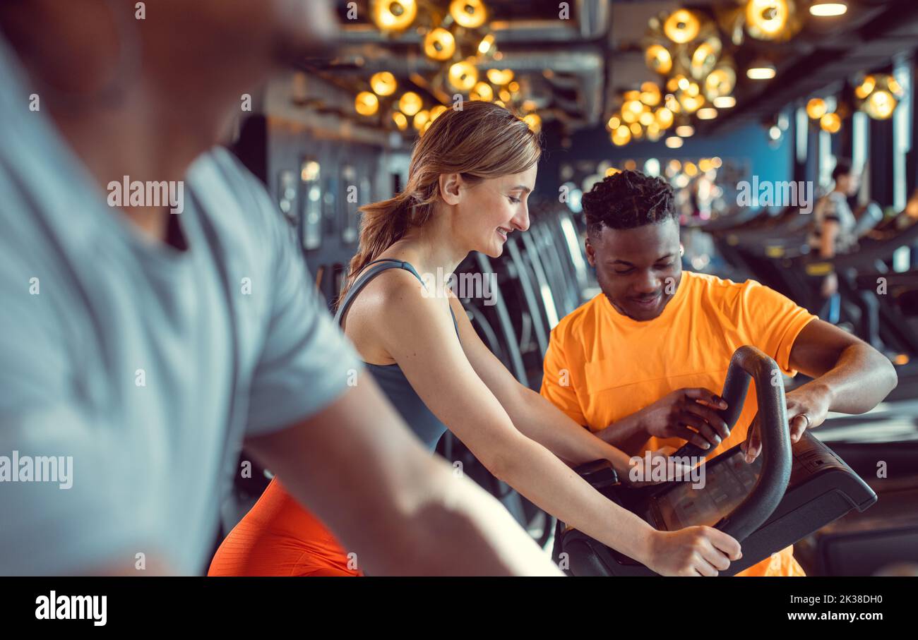 Group of diversity friends exercising on bike in gym Stock Photo - Alamy