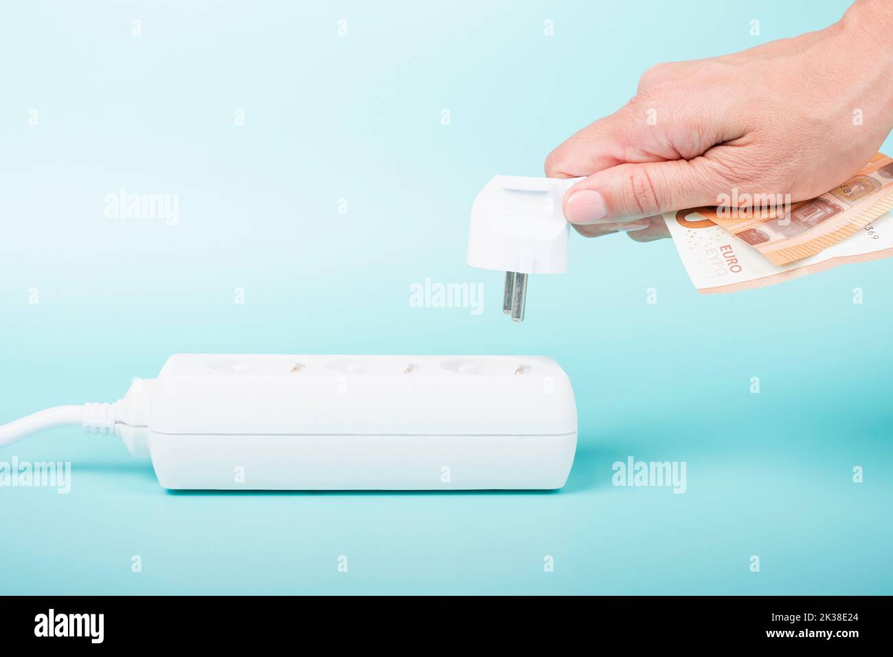 Woman hand holding electric power plug with Euro banknote on cord and ...