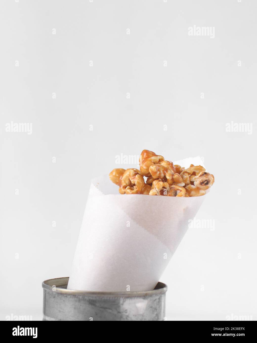 Caramel popcorn in white parchment cone Stock Photo - Alamy