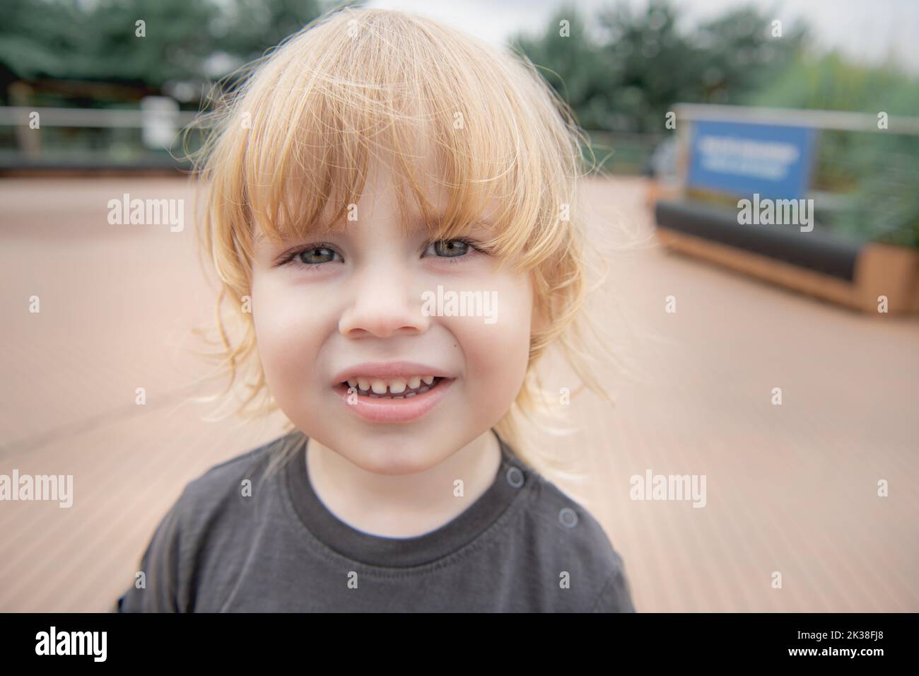 Tired blond boy face portrait on blurry background Stock Photo - Alamy