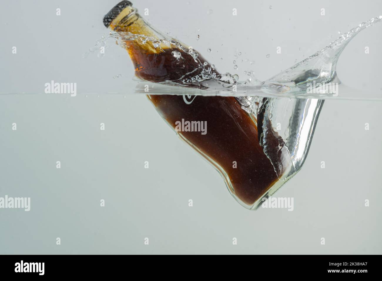 Close up view of drink Coca Cola bottle falling into water isolated on ...